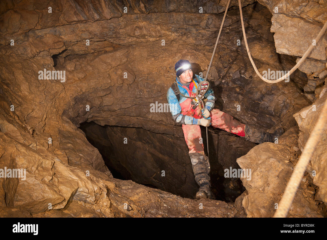 female athlete exploring a cave; fernie, british columbia, canada Stock ...
