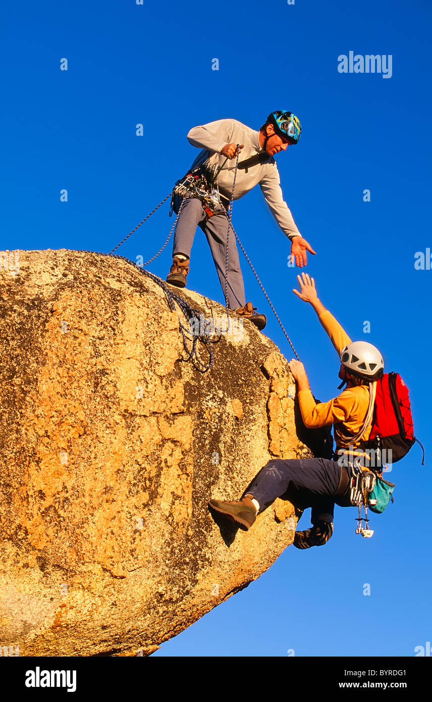 Team of climbers reaching the summit of a rock pinnacle Stock Photo - Alamy
