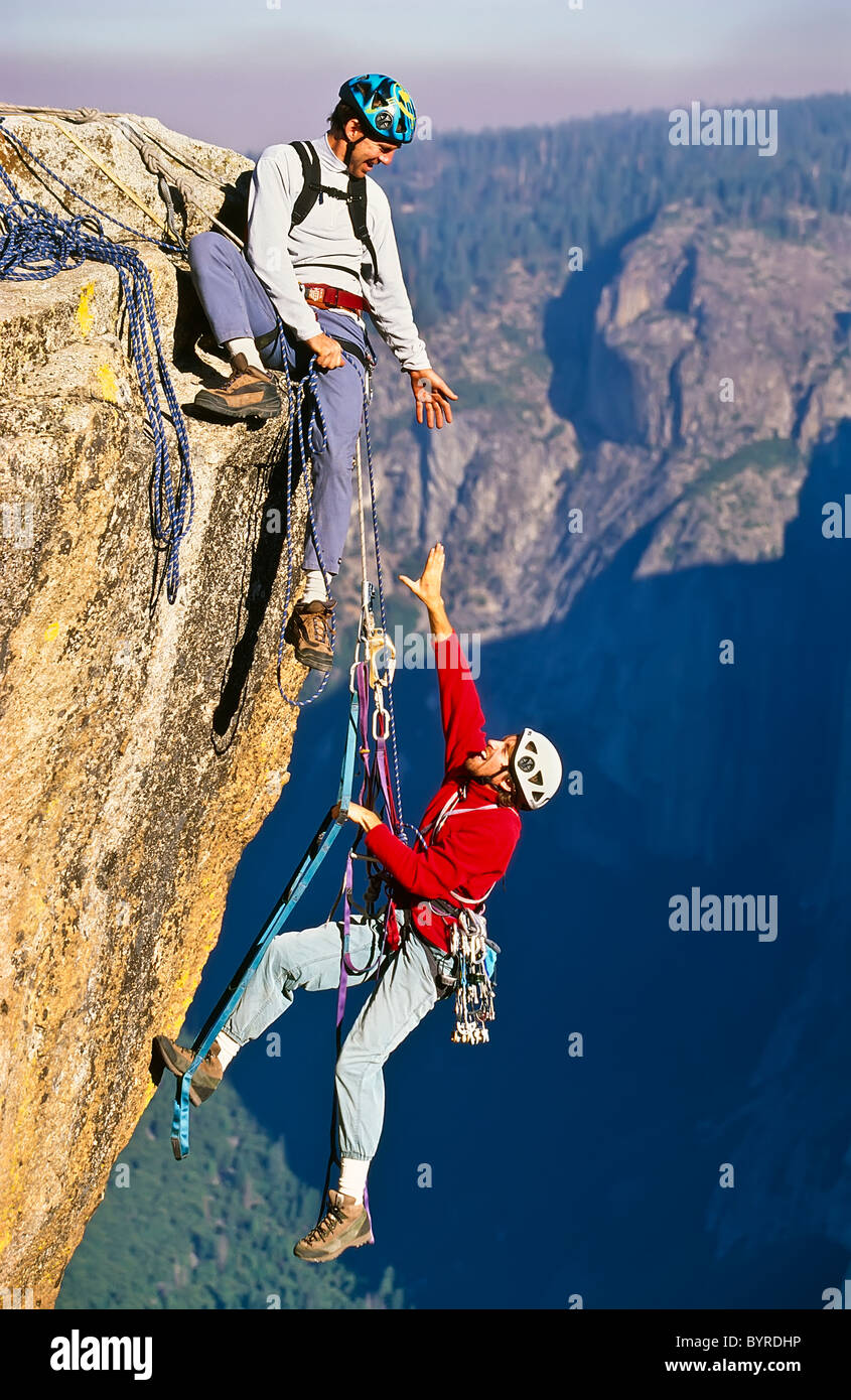 Team of climbers reaching the summit of a rock pinnacle Stock Photo - Alamy