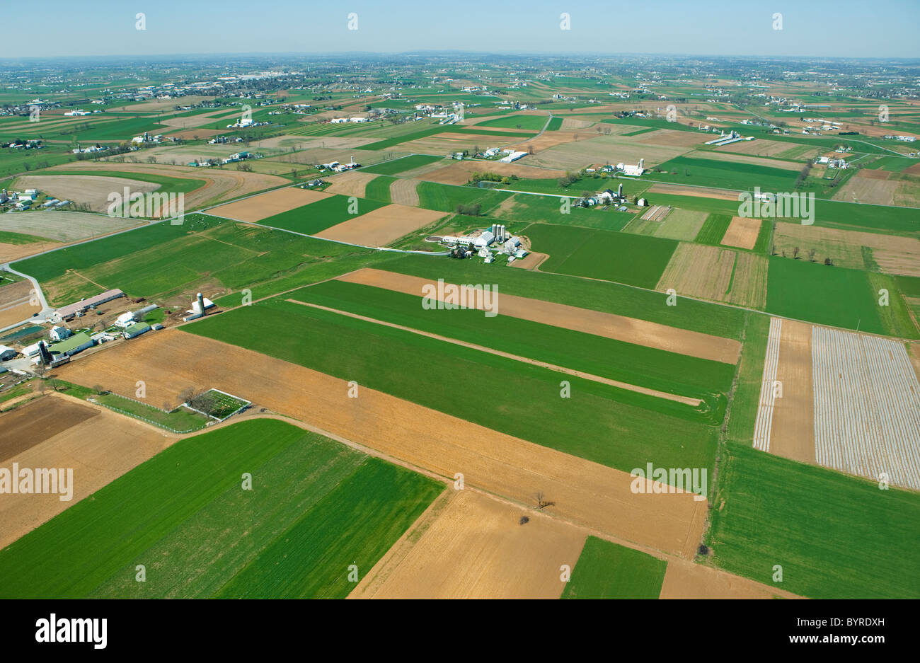 Agriculture - Aerial view of farmsteads and agricultural fields in mid ...