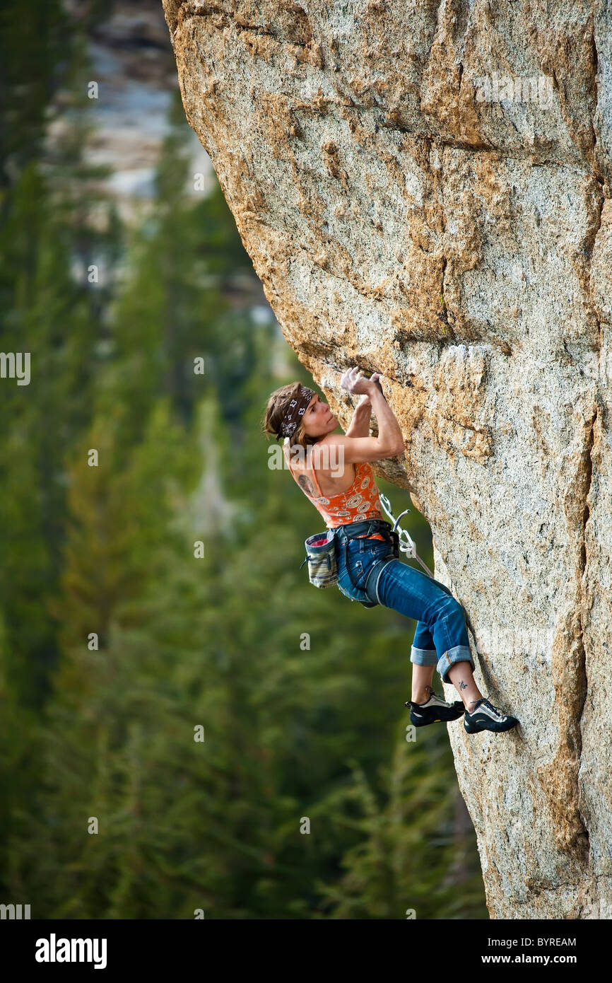 Female climber clinging to an overhanging rock face Stock Photo - Alamy