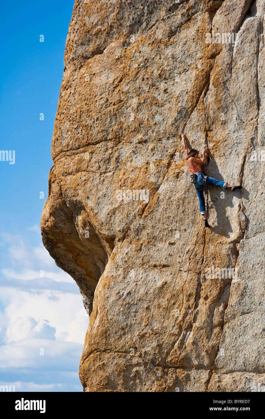 Female climber clinging to an overhanging rock face Stock Photo - Alamy