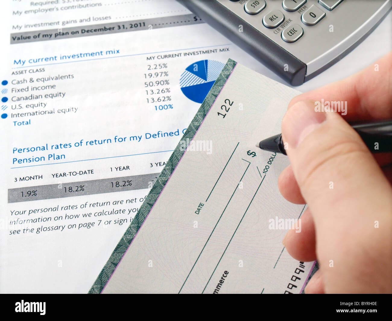 Man filling out cheque on the investment papers Stock Photo - Alamy