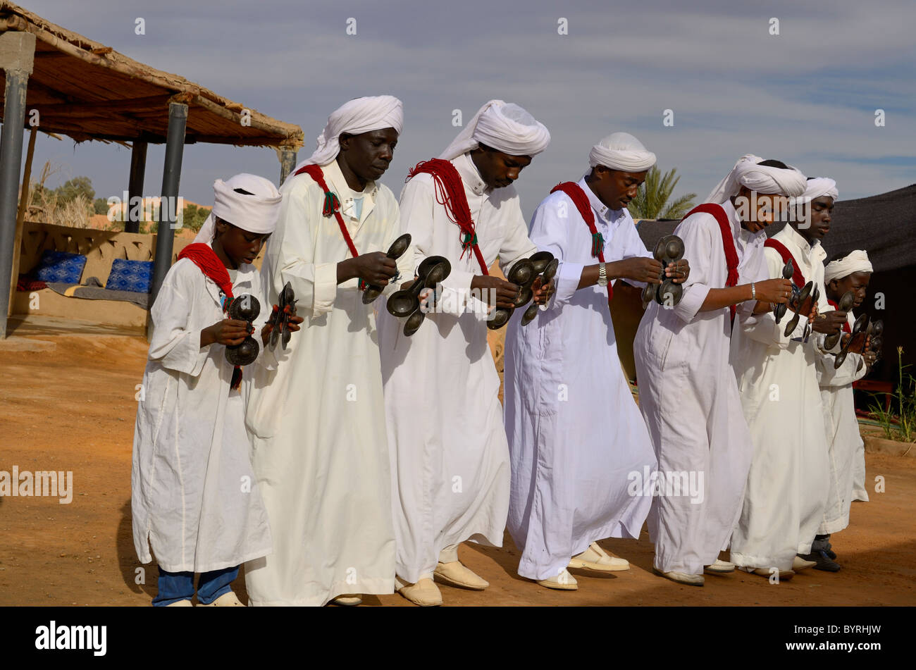 Group of Gnawa musicians in white turbans and jellabas dancing and ...