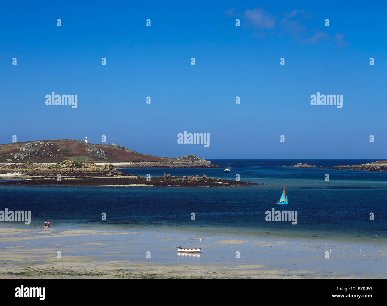 A family stand on the white sands of Pentle Bay, Tresco, Scilly Isles ...