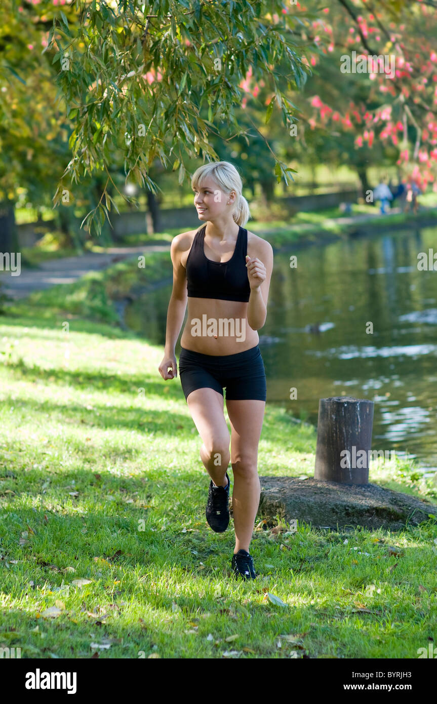 Pretty young girl running in the forest near river Stock Photo - Alamy