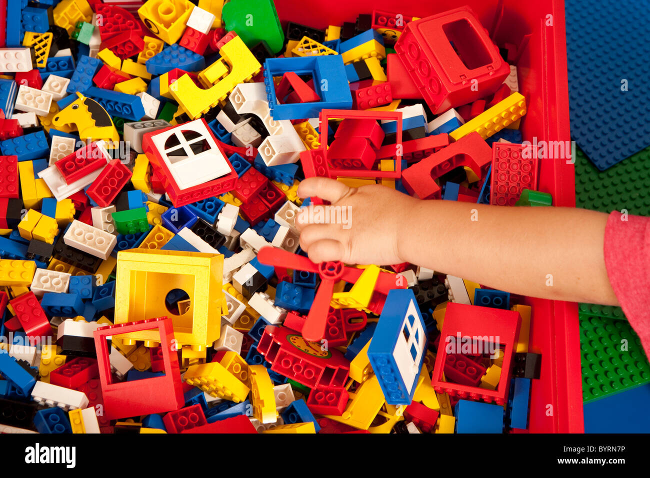 Child reaches for a building block piece Stock Photo - Alamy