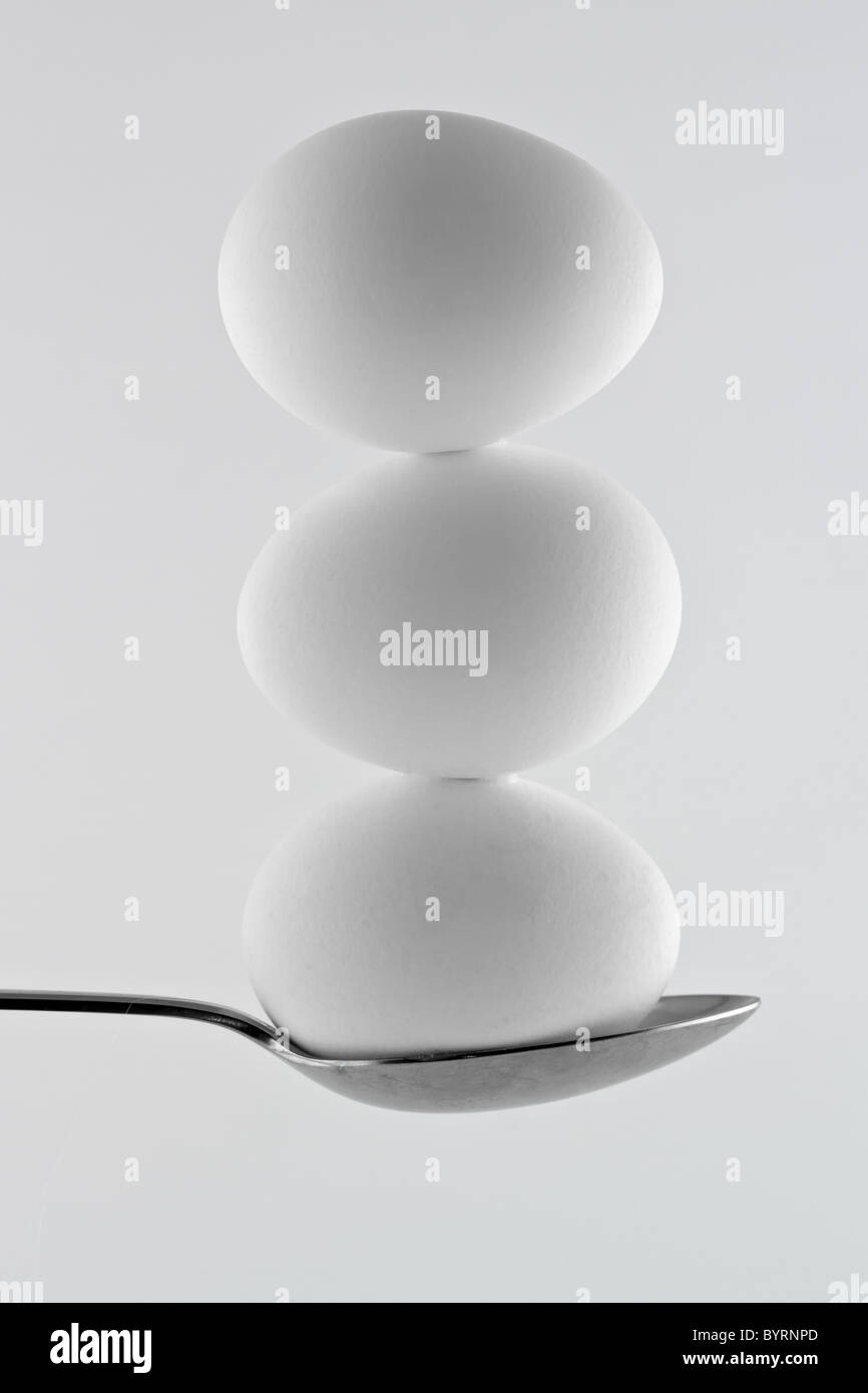 Three white eggs balancing on a spoon Stock Photo - Alamy