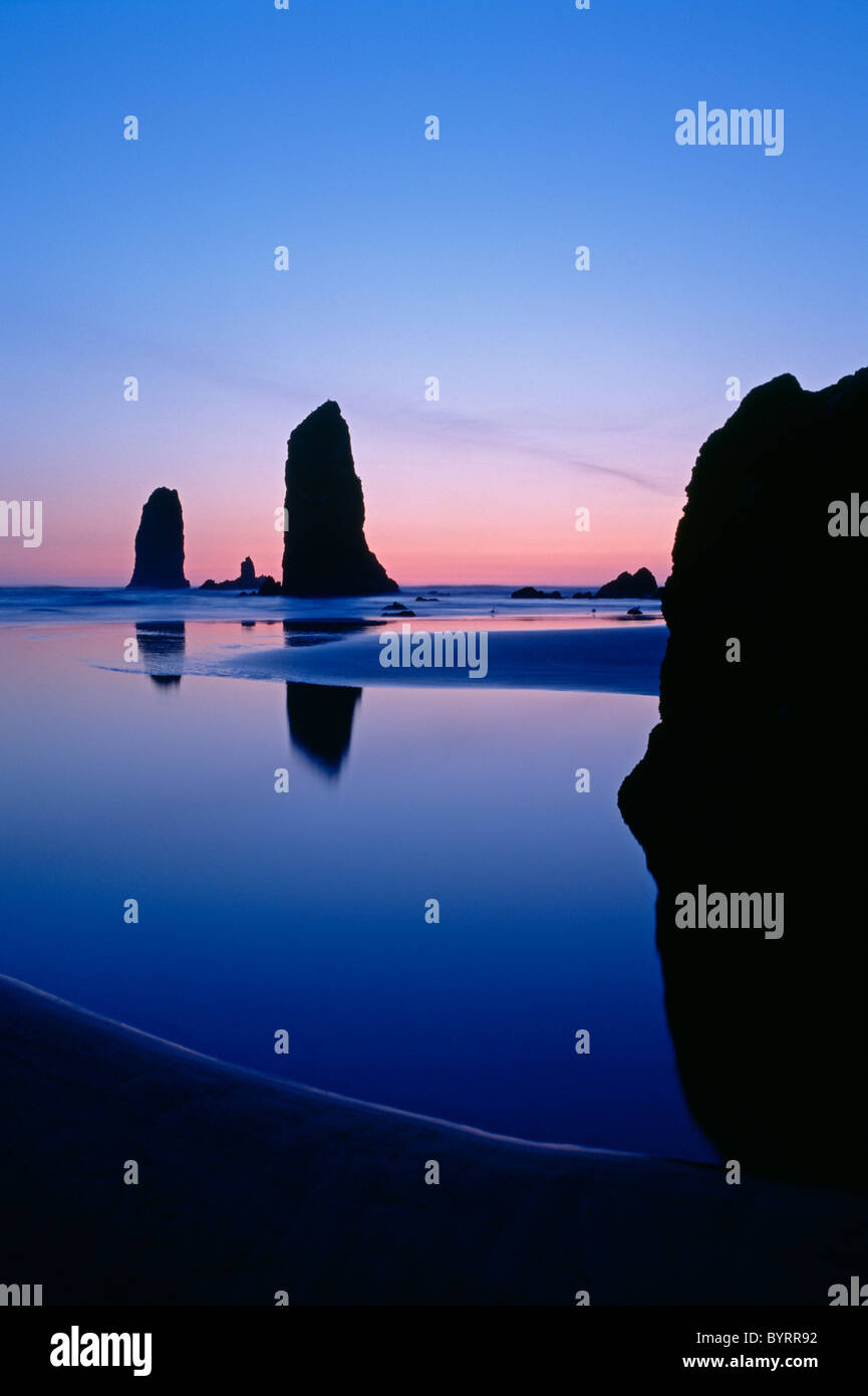 Silhouetted rock formations the Needles with tidal pools at sunset ...