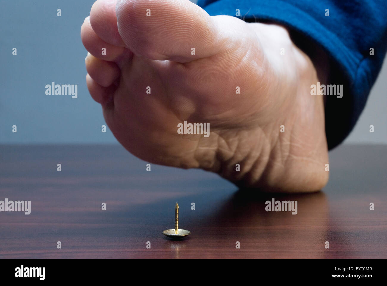 barefoot stepping over drawing pin Stock Photo - Alamy