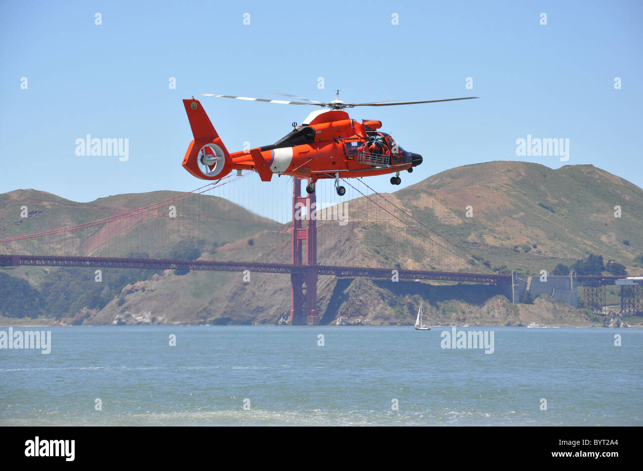 Rescue helicopter above the water with the Golden Gate Bridge and blue ...