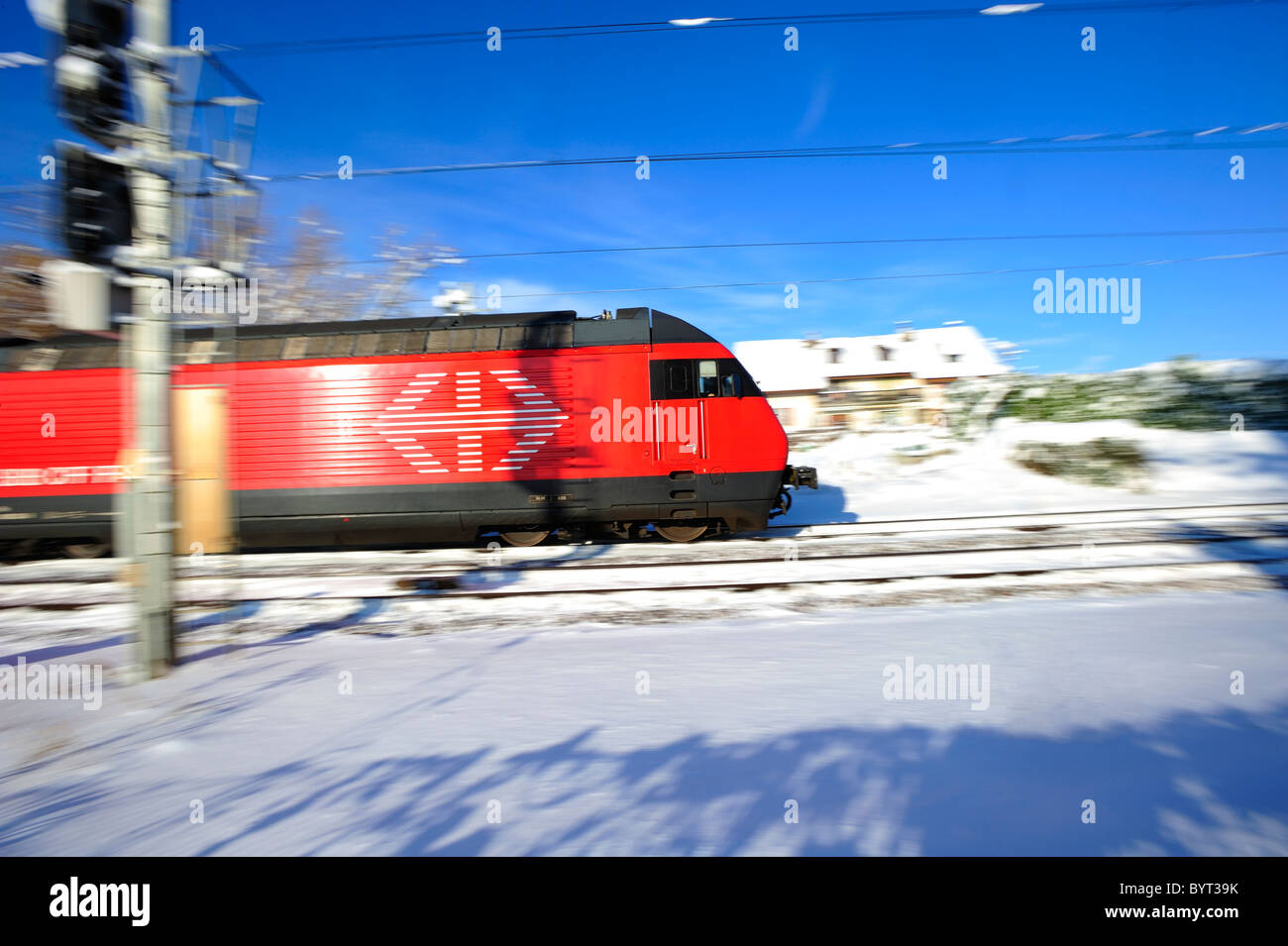 A Swiss train speeding through a snowy landscape in mid-winter. Motion ...