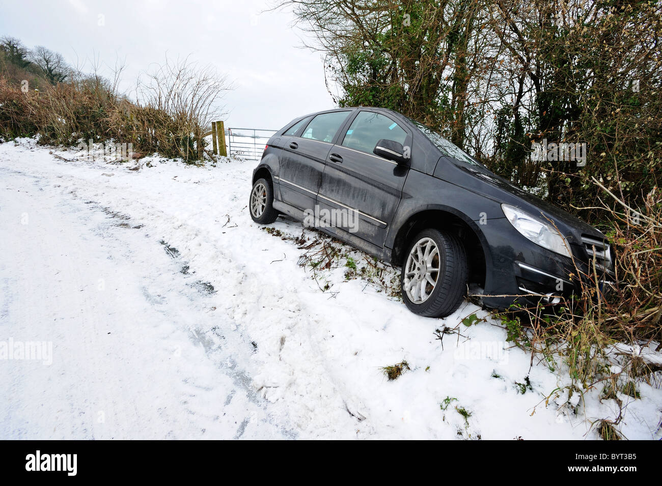 Car in the ditch. A car crashed into the hedge on the bend of an icy ...