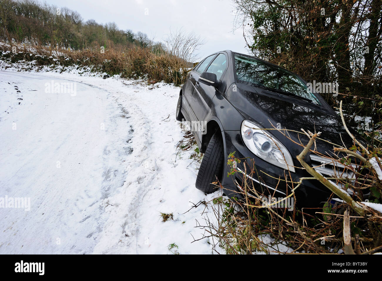 Car in the ditch. A car crashed into the hedge on the bend of an icy ...