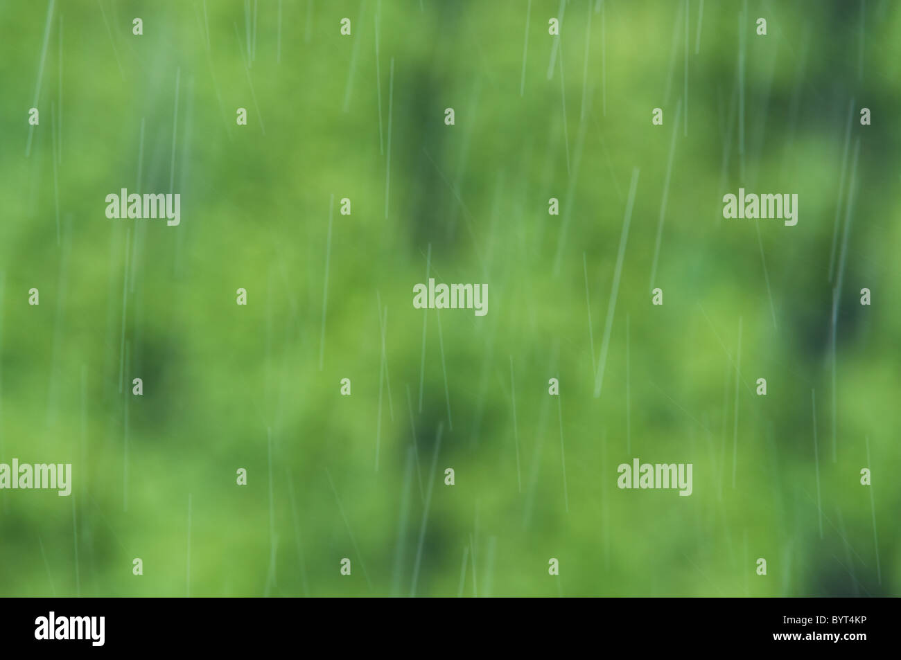 raindrops falling down on green blurry background Stock Photo - Alamy