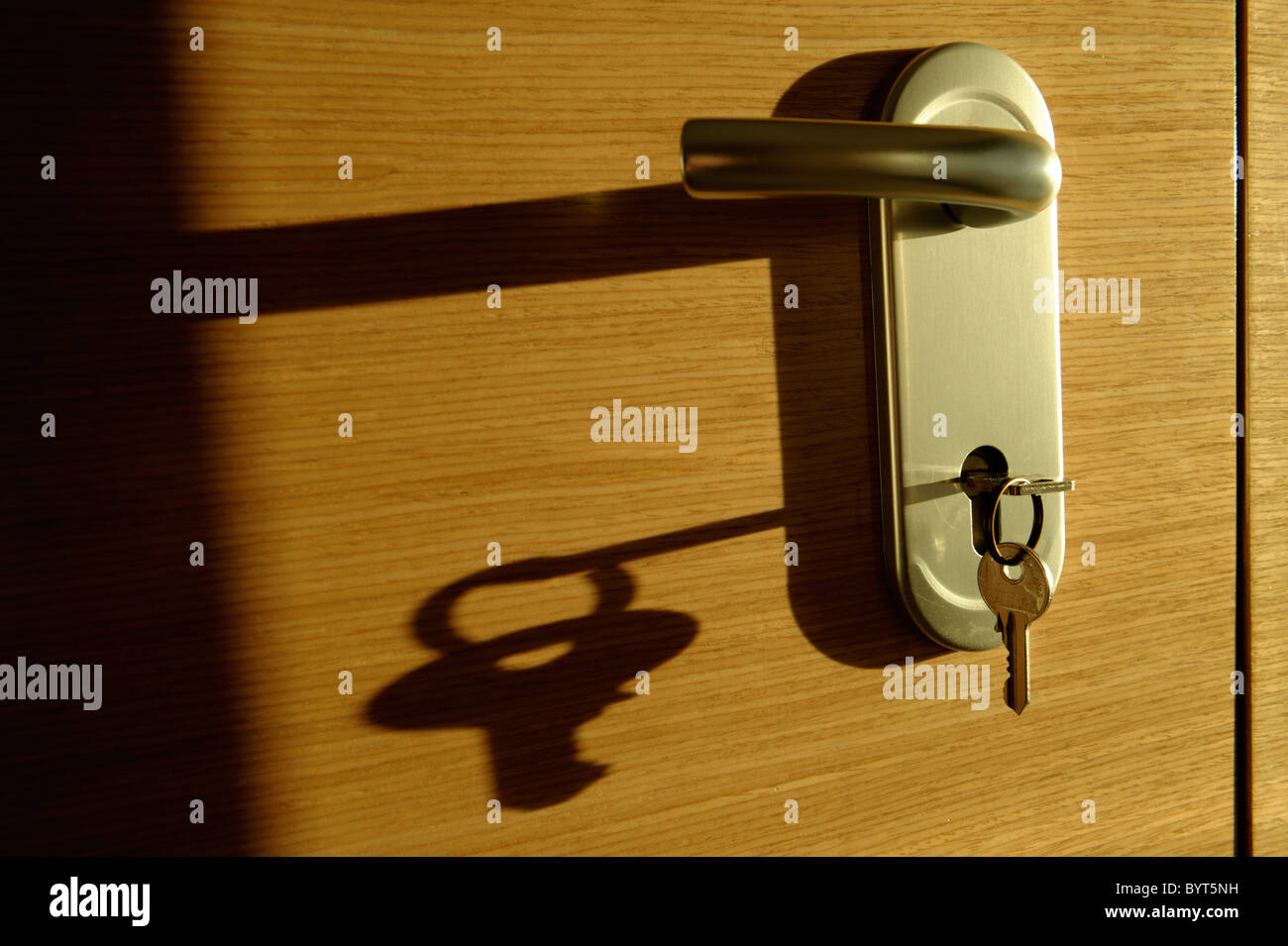 Keys in door lock casting a long shadow Stock Photo - Alamy