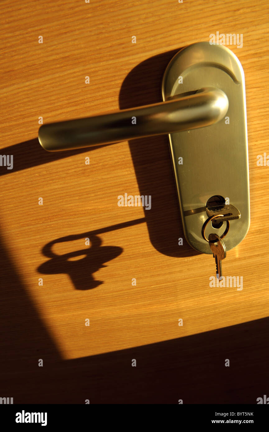 Keys in door lock casting a long shadow Stock Photo - Alamy