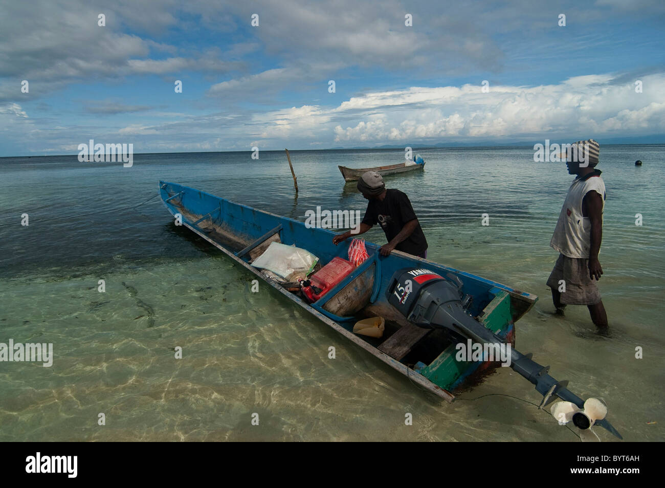 two fisherman loading the livestock and fuel on the boat as they're ...