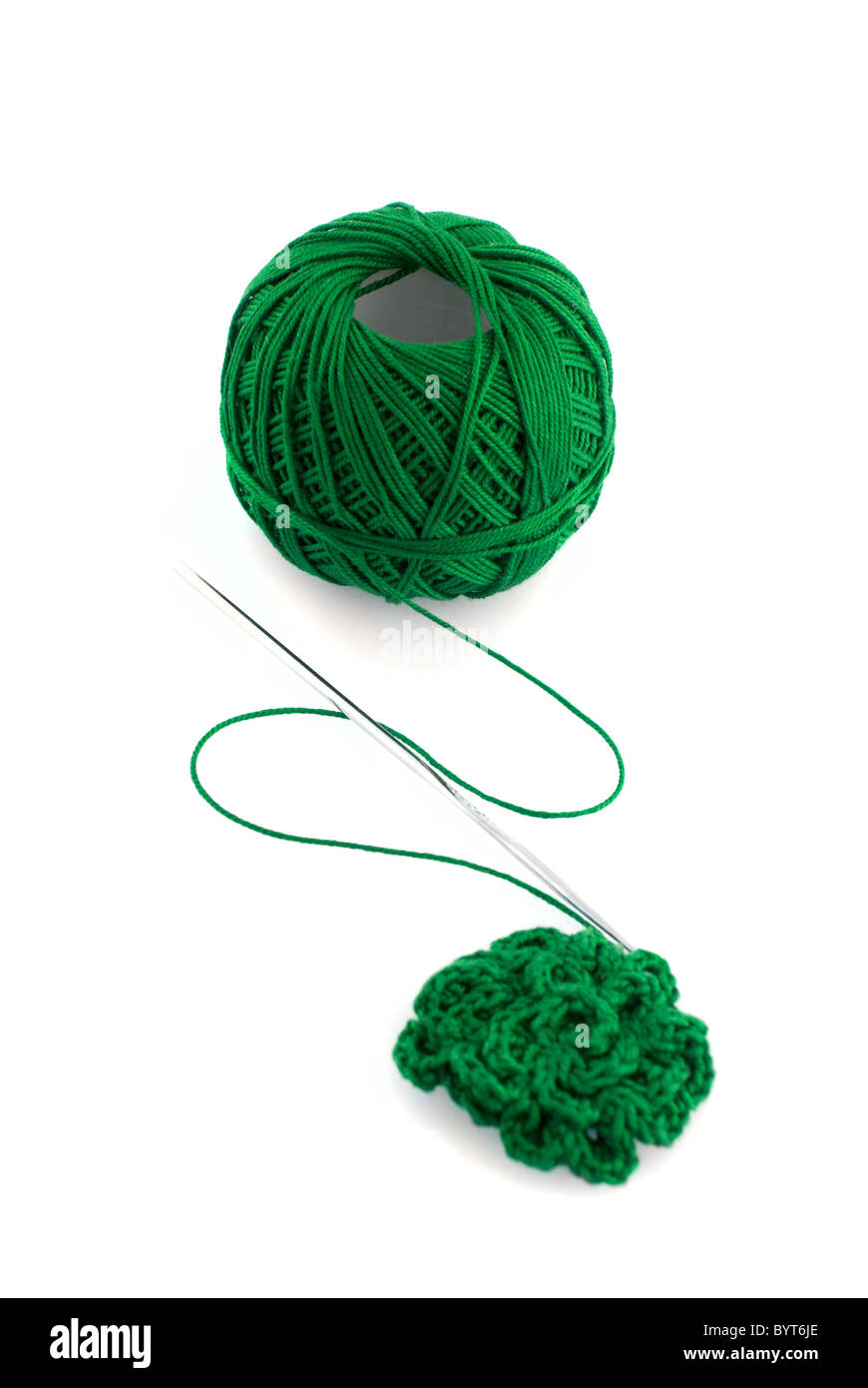 Green spool and needle on a white background Stock Photo - Alamy