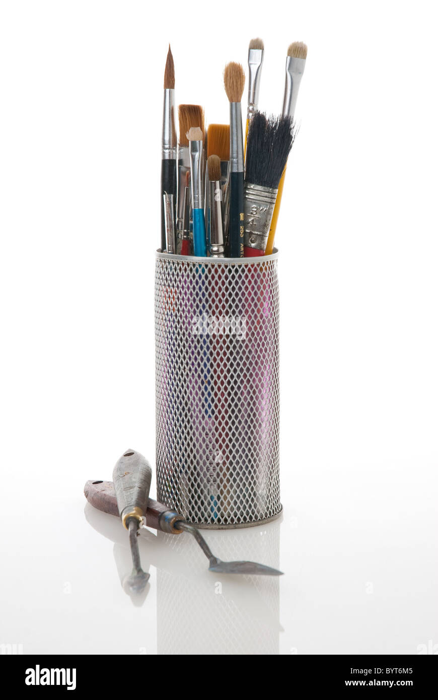 Paintbrushes in a metal mesh holder on white background Stock Photo - Alamy