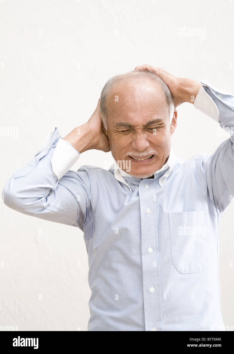 Senior man putting hands on his head Stock Photo - Alamy