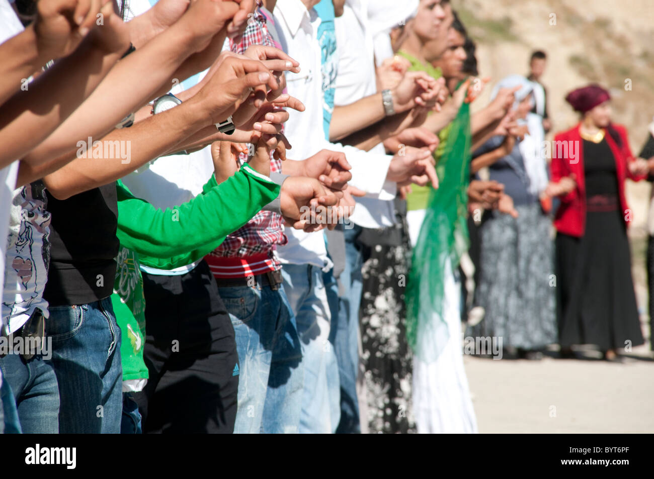 Kurdish men and women holding hands during a traditional wedding circle ...