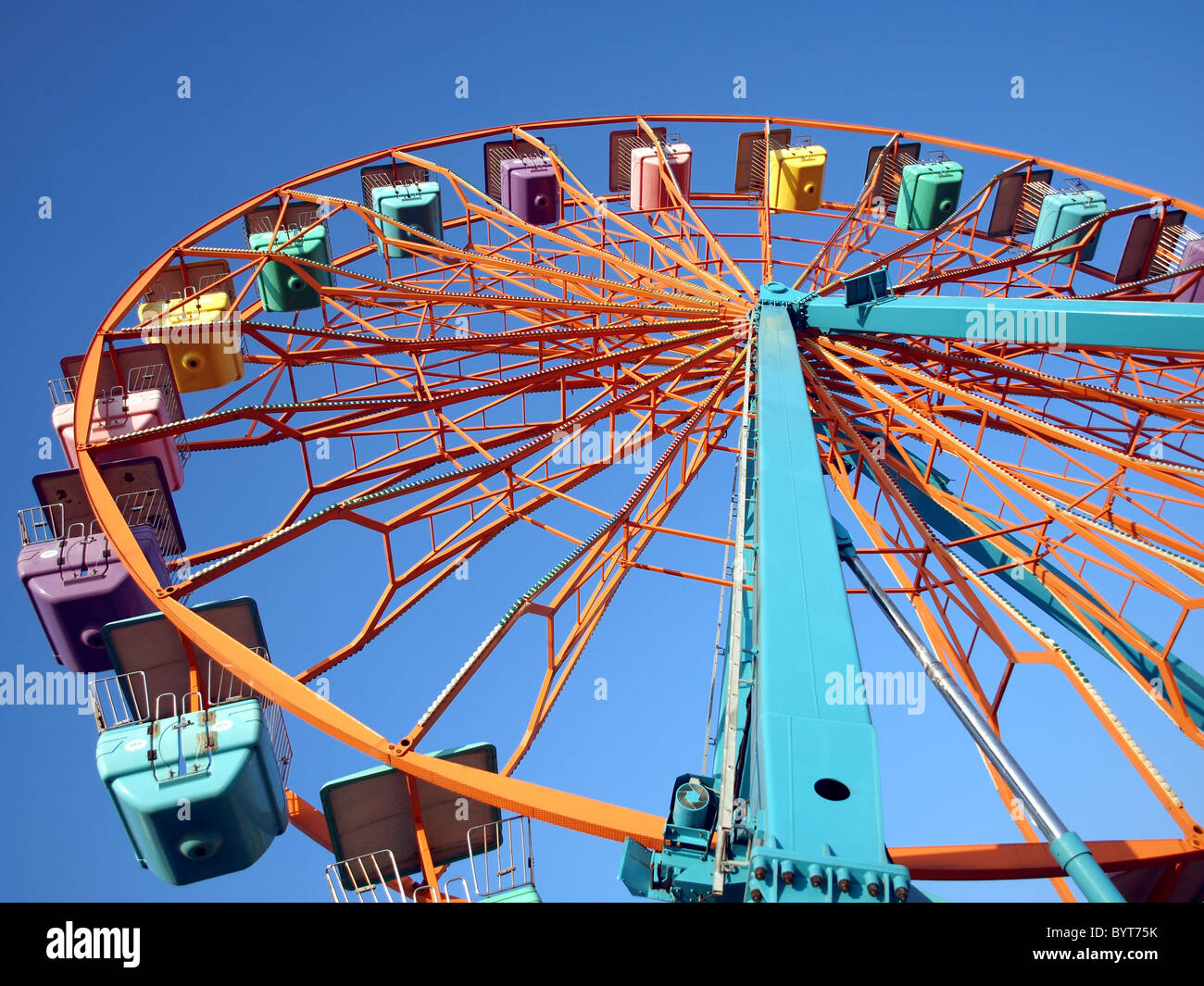 A ferris wheel with colorful cabins at a local fun fair Stock Photo - Alamy