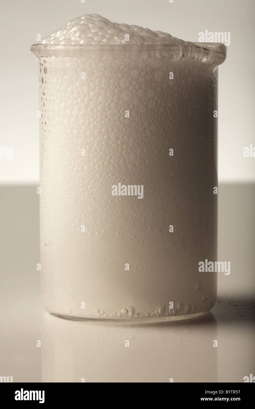 effervescent table dropped in a laboratory beaker full with water ...