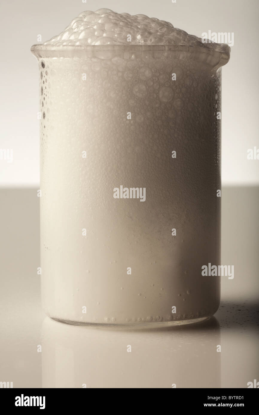 effervescent table dropped in a laboratory beaker full with water ...