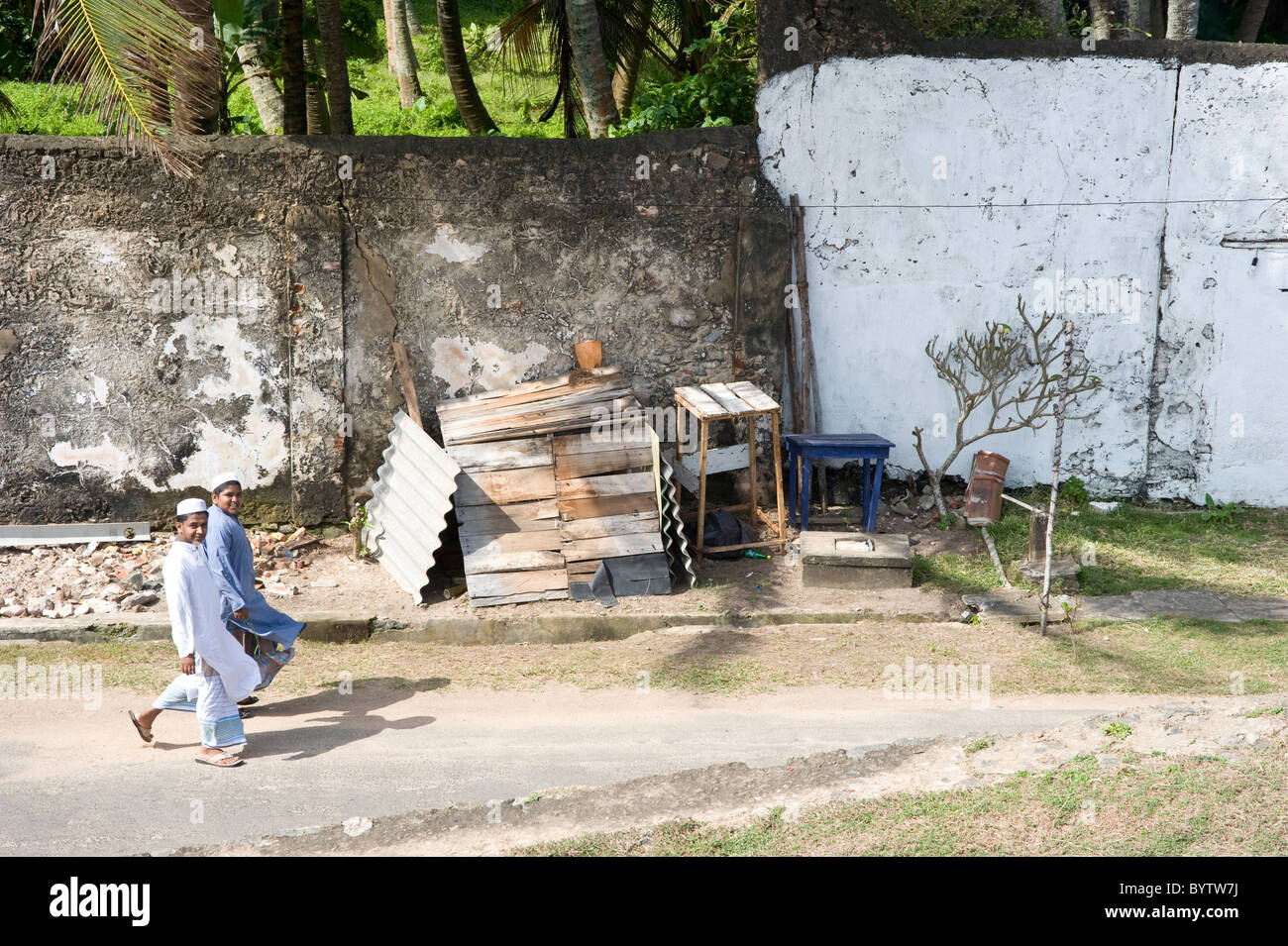 two Muslim boys walking along road looking at camera Stock Photo - Alamy
