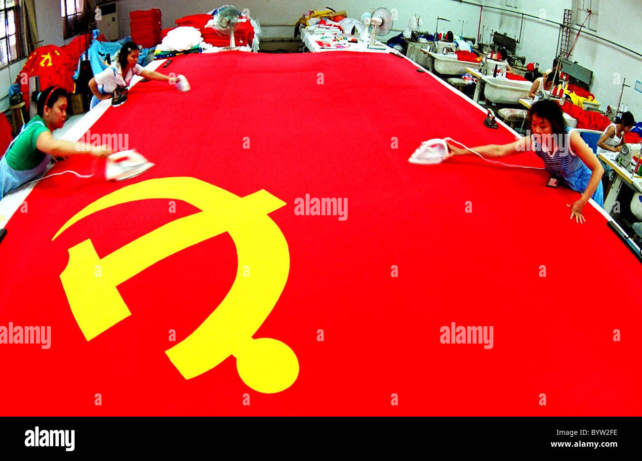 * FLAGGED DOWN Several women iron out the kinks from a super large flag ...