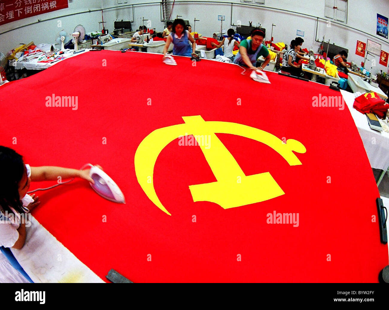 * FLAGGED DOWN Several women iron out the kinks from a super large flag ...