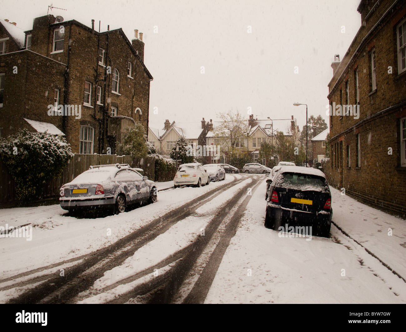 snow fall on a side street down a road in london Stock Photo - Alamy