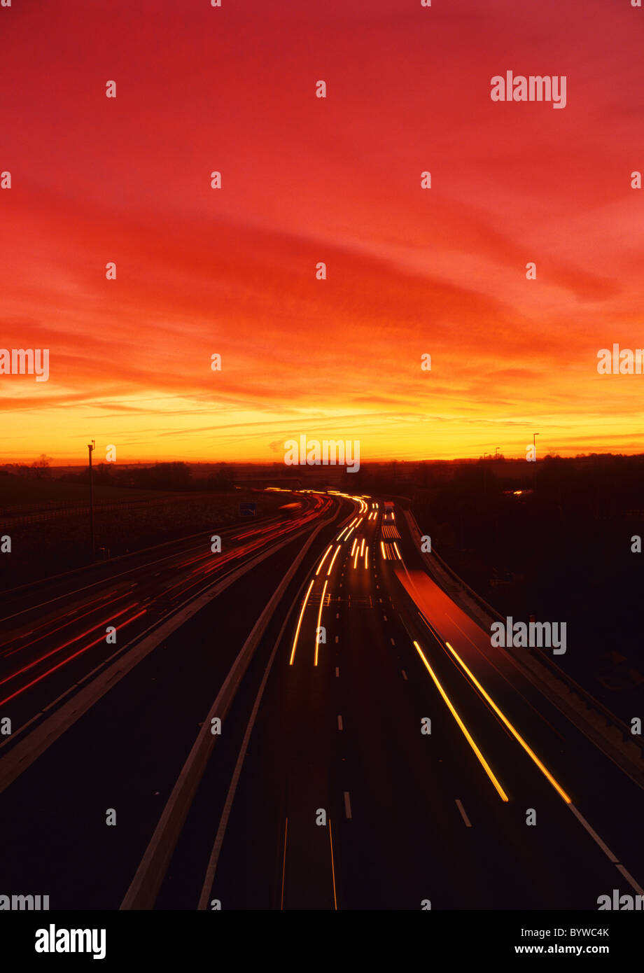 headlight trails of traffic travelling on the M1 motorway at sunset ...