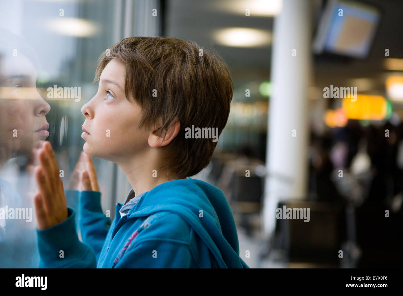 Young boy looking through a window Stock Photo - Alamy