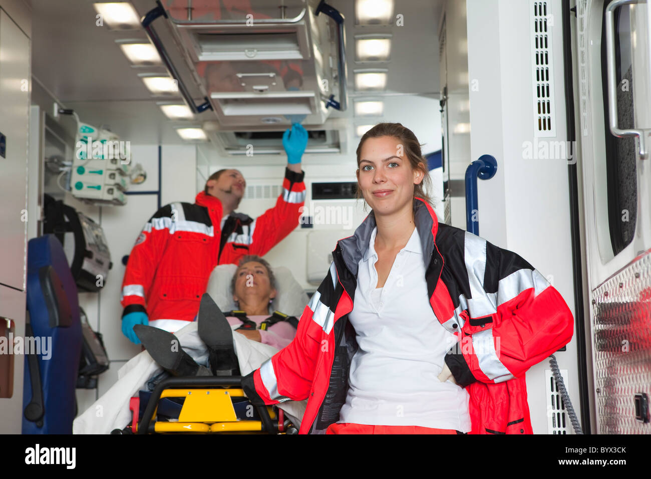 Ambulance team with patient in coach Stock Photo - Alamy