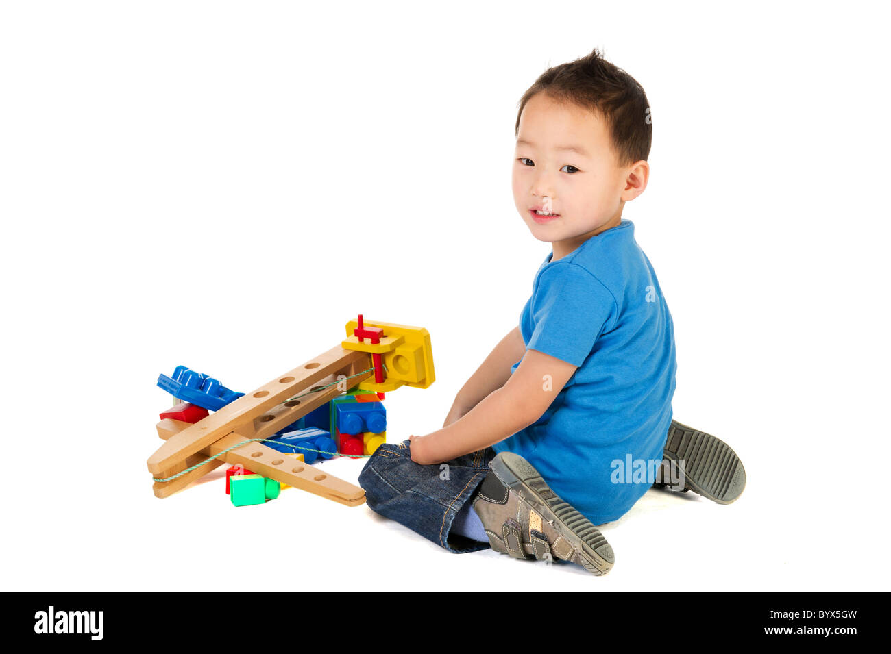 Little Chinese disabled boy with one hand playing with wooden crane an ...