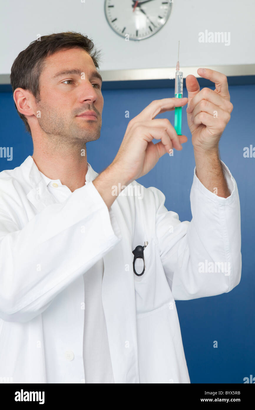 Doctor inspecting injection Stock Photo - Alamy