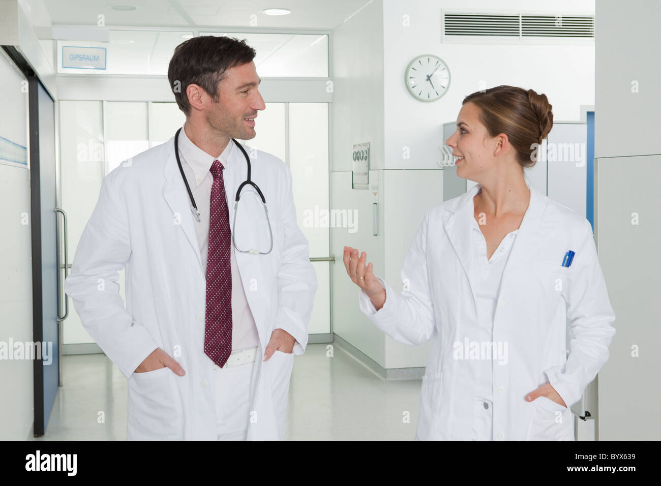 Nurse and doctor discussing in hall Stock Photo - Alamy