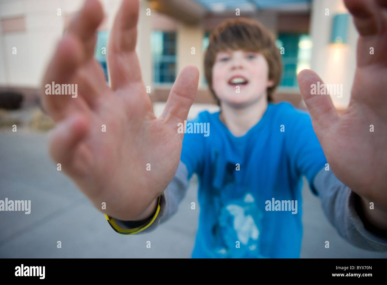Eleven year old boy reaching his hands out to camera, begging for ...