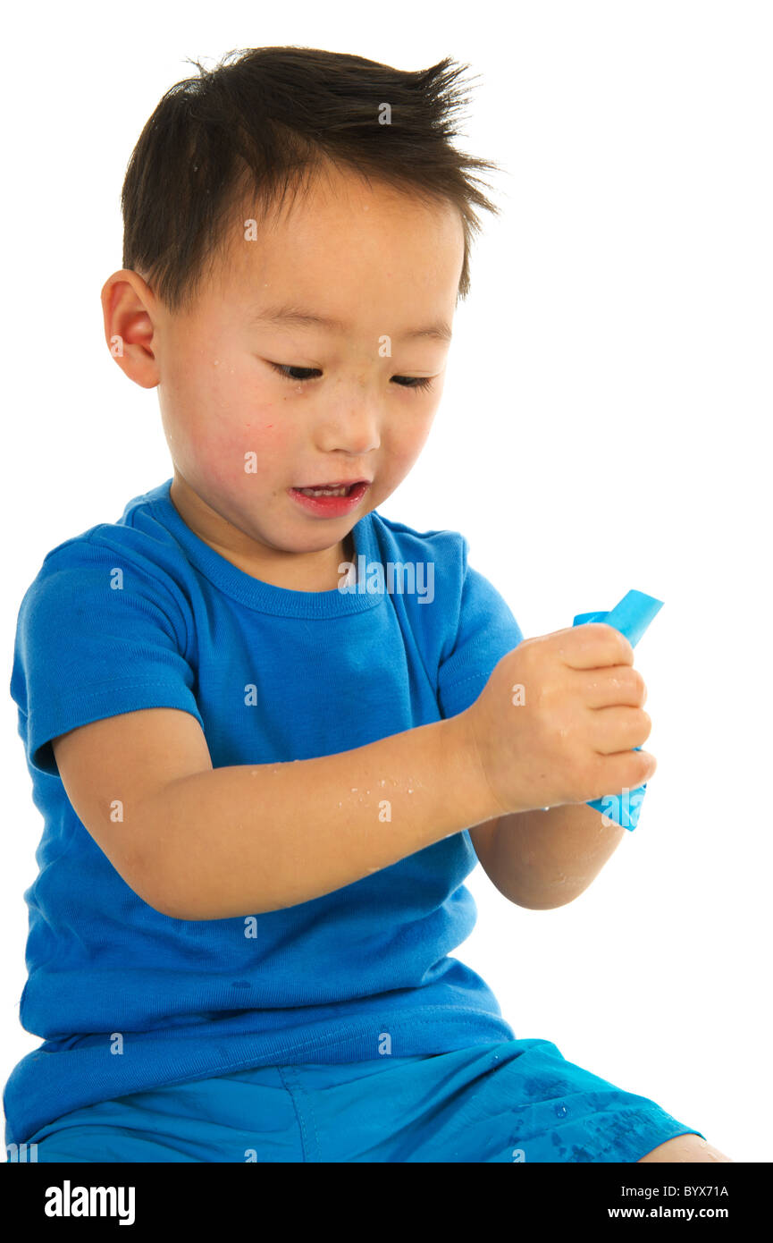 Portrait of a Chinese boy which is folding a paper boat isolated over ...