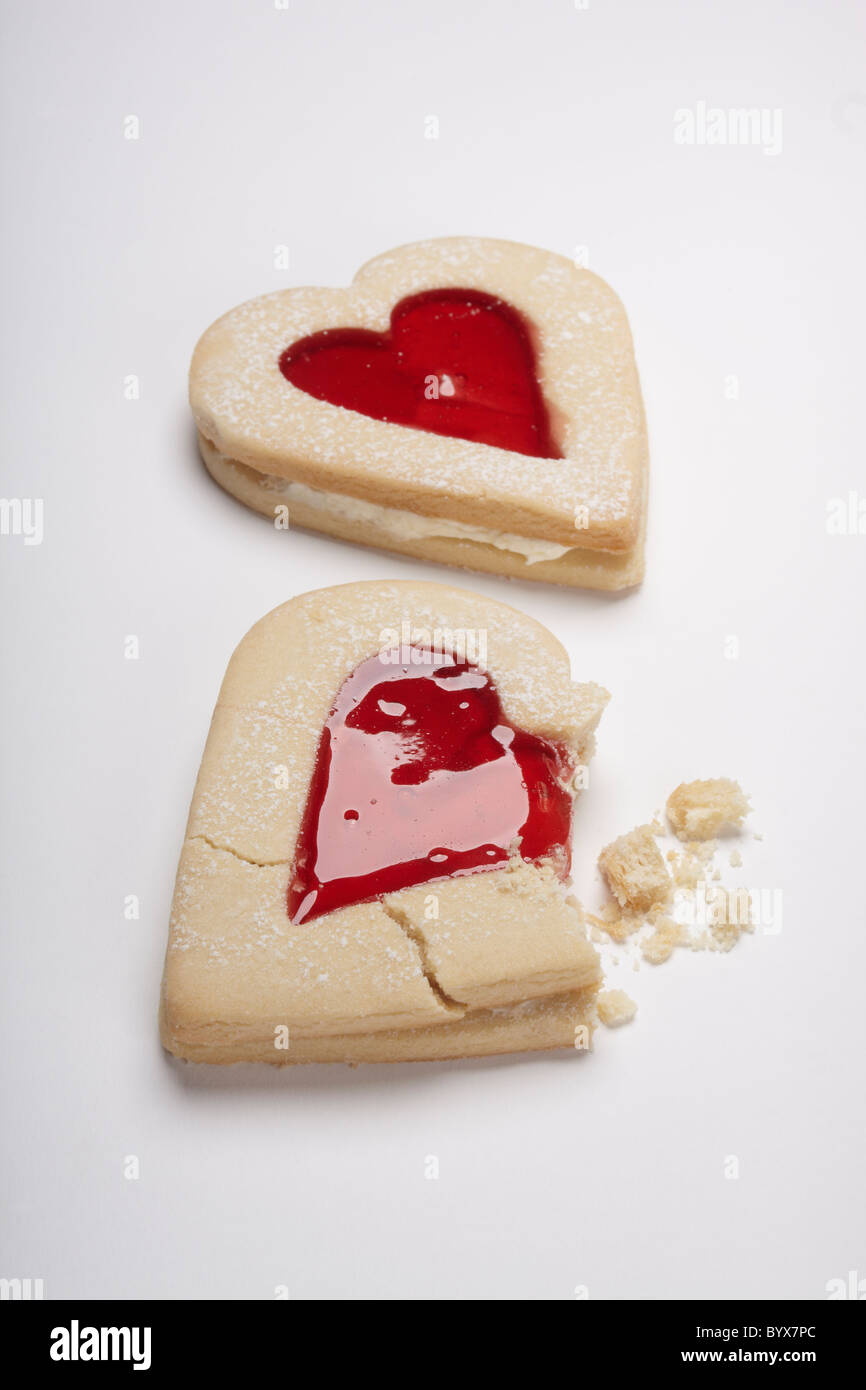 Photograph of heart shaped biscuits filled with red jam on a white ...