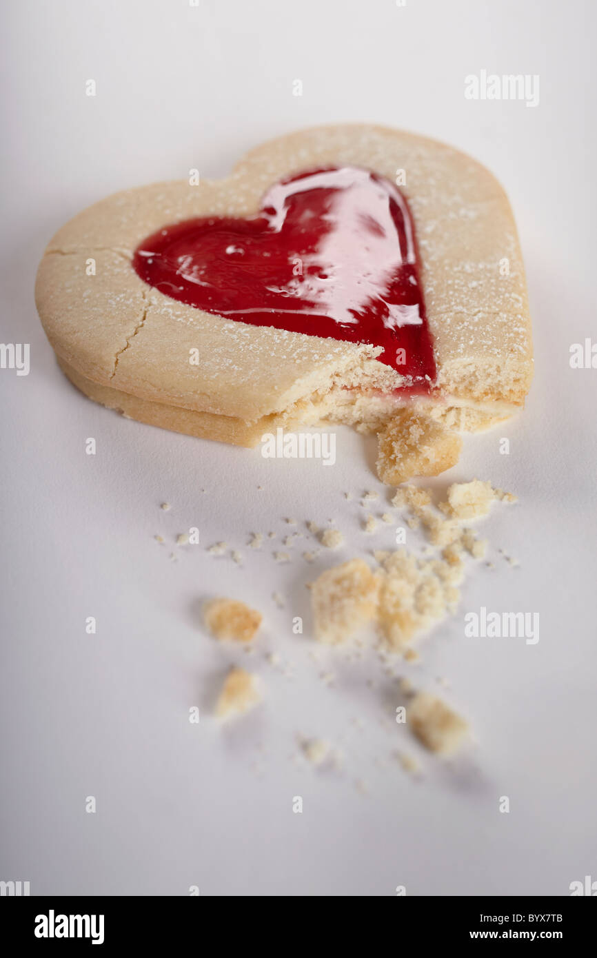Photograph of heart shaped biscuits filled with red jam on a white ...