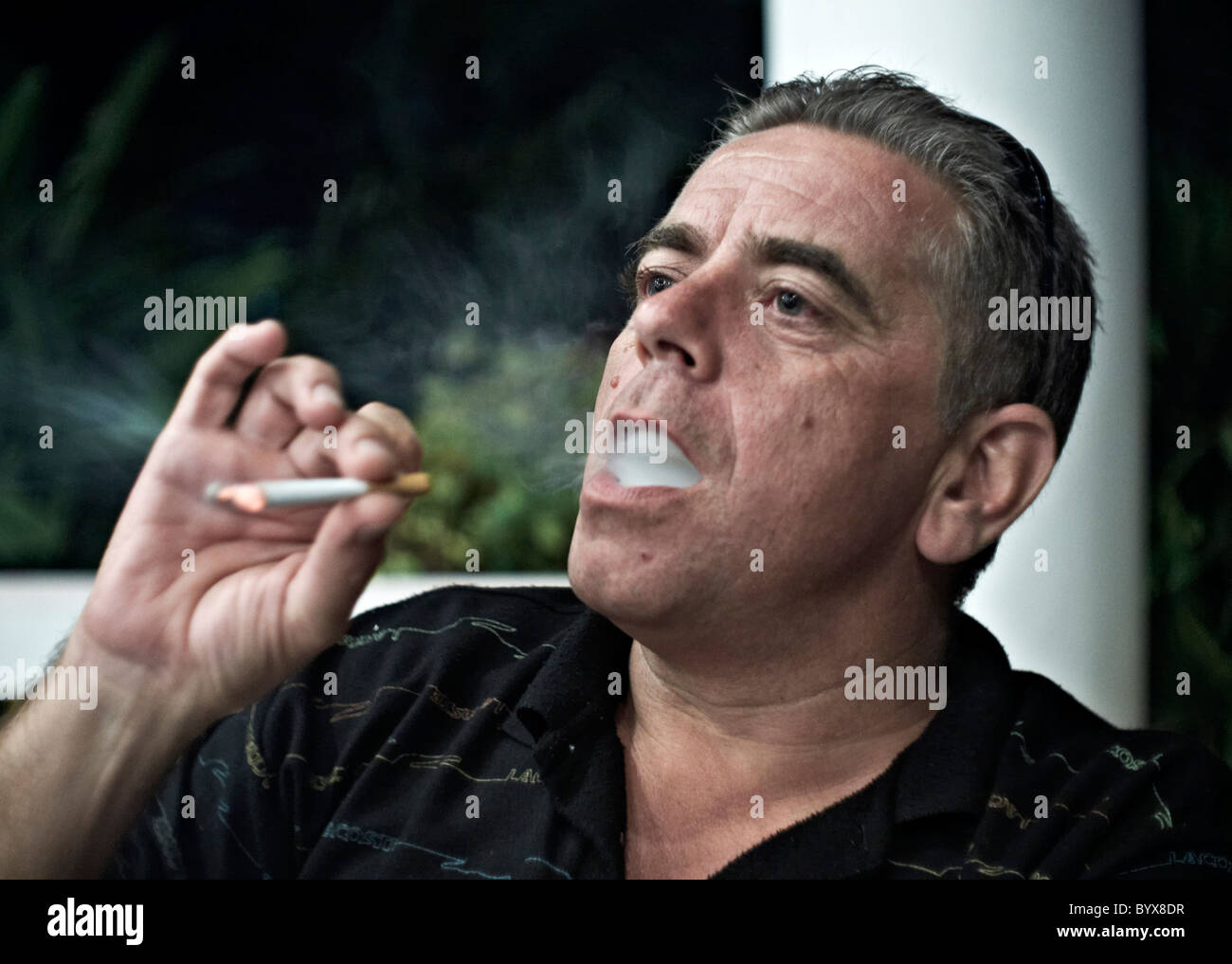 Man smoking a cigarette and deeply inhaling smoke Stock Photo - Alamy