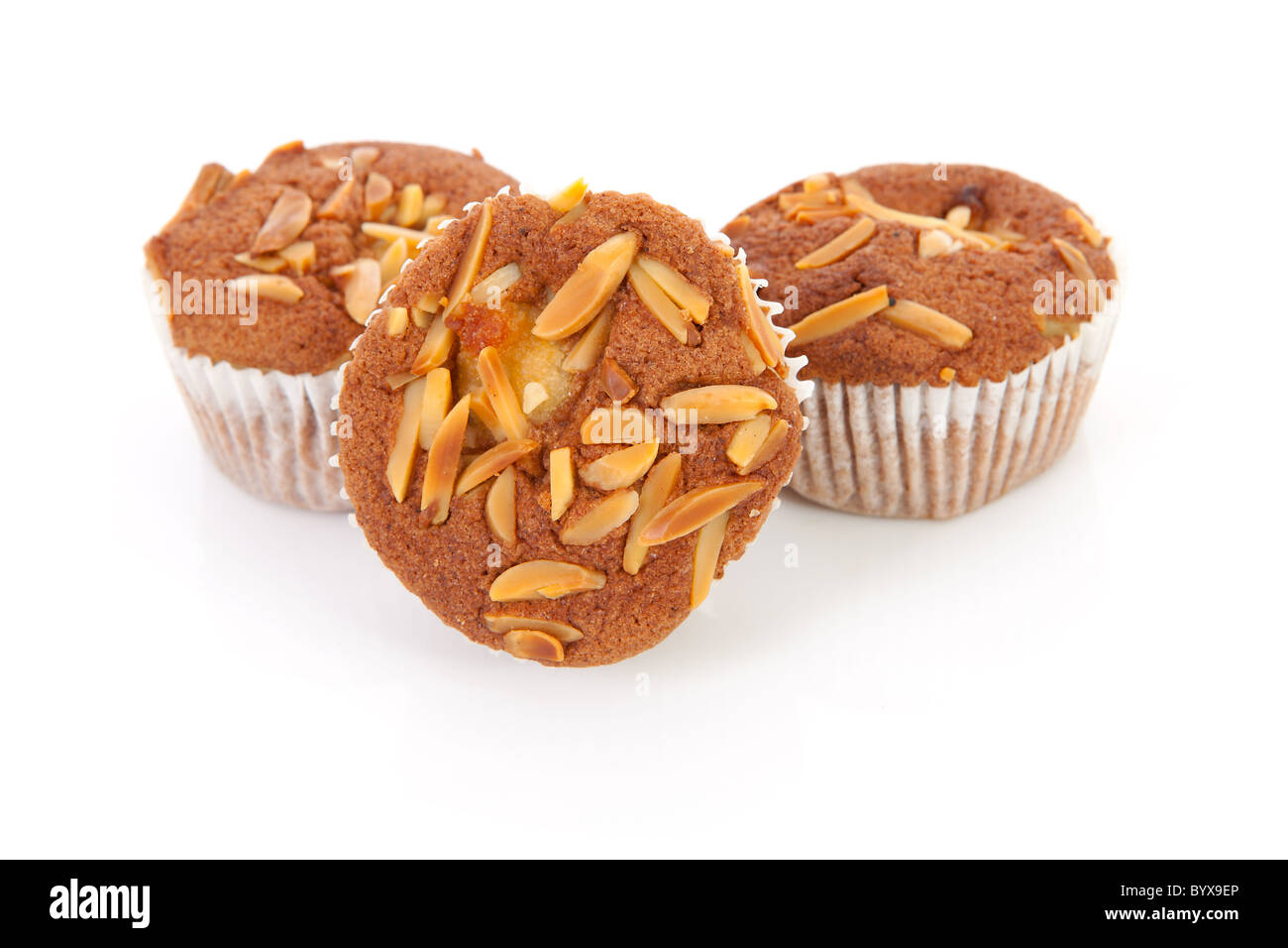 three biscuit cupcakes with nuts over white background Stock Photo - Alamy
