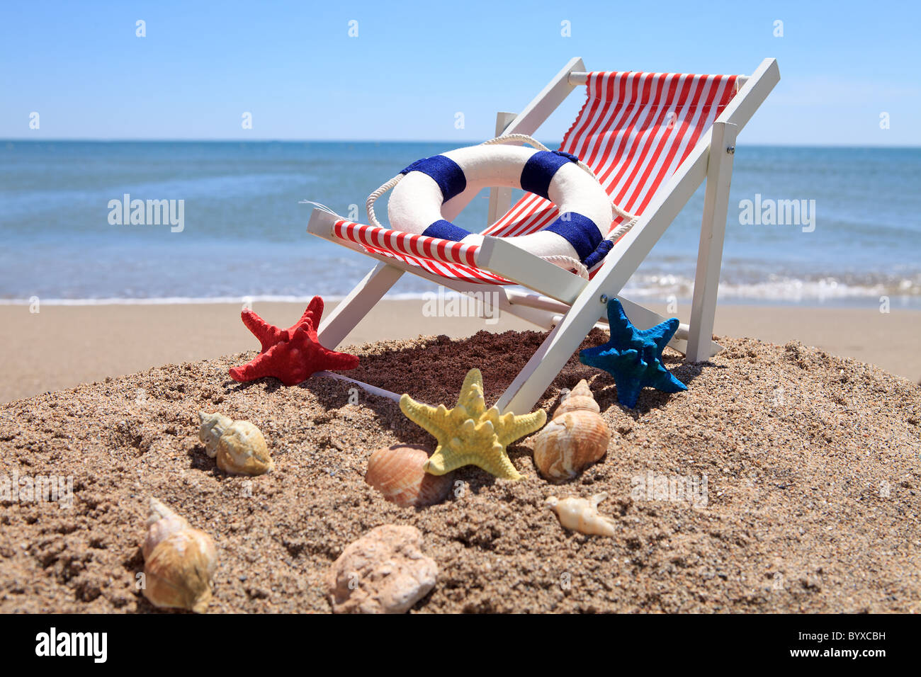 Beach chair near the ocean with shells on sunny day Stock Photo - Alamy
