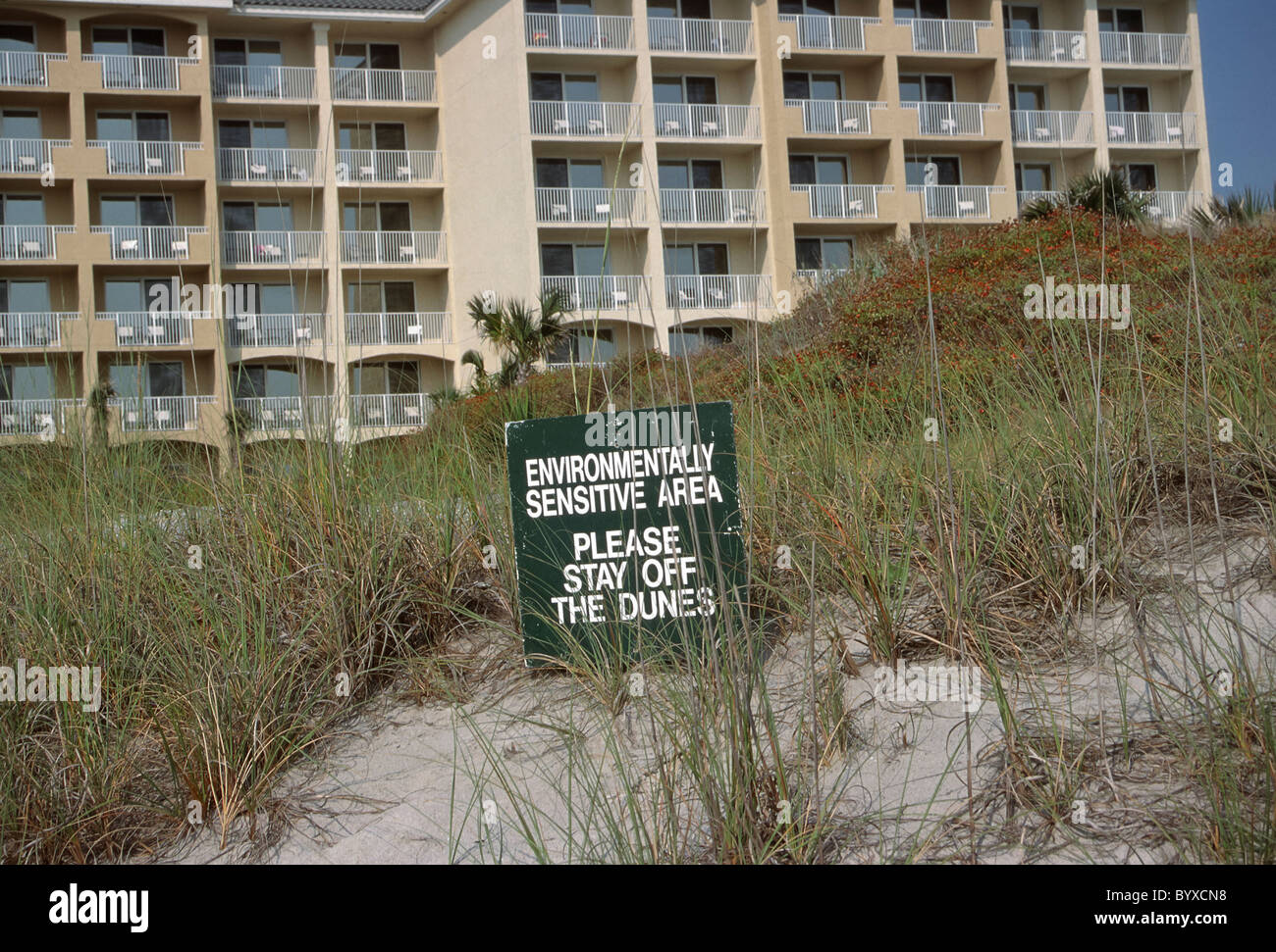 warning sign protecting sand dunes next to beach side resort on Amelia ...
