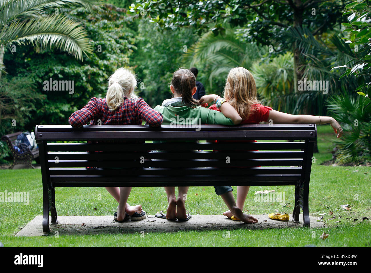 Teenage girls sitting on a bench Stock Photo - Alamy