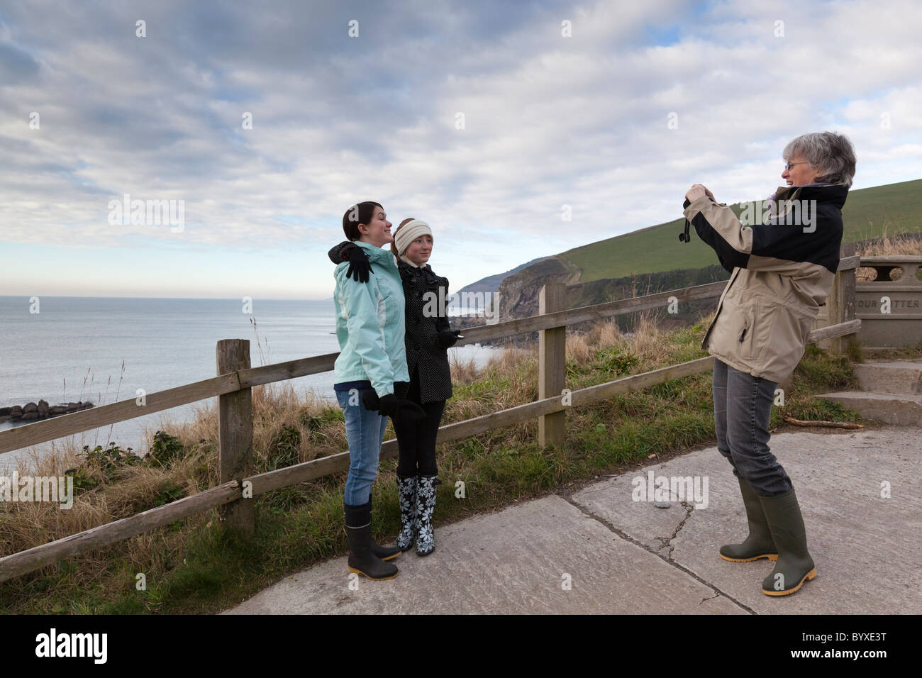 Two girls having their photograph taken by the sea in Cornwall, England ...