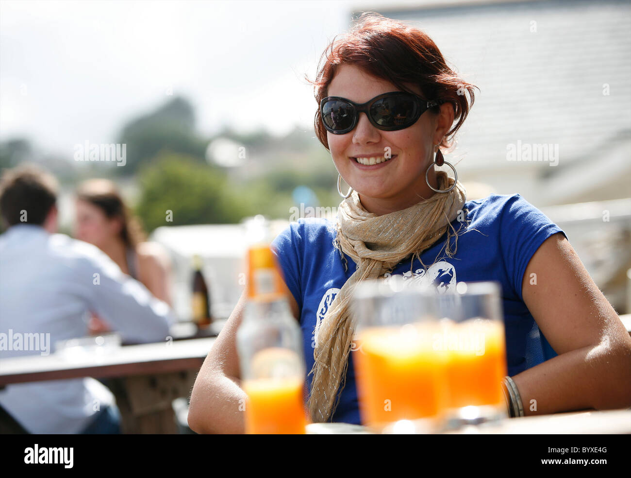 A group of girls socialising and enjoying a drink at a bar outside in ...